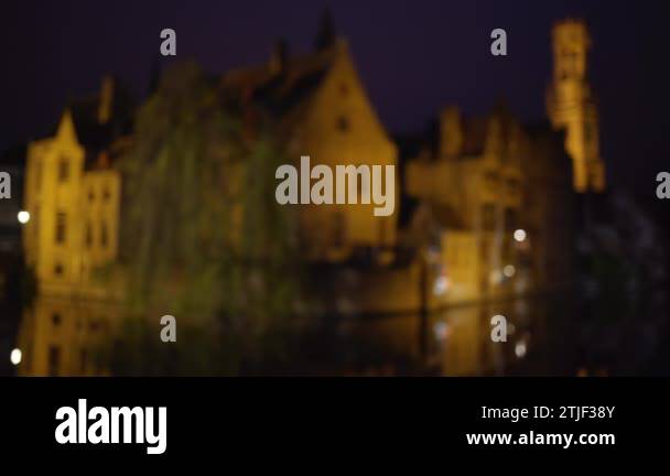 Panning out of focus background plate of Bruges canals at night. Moving ...