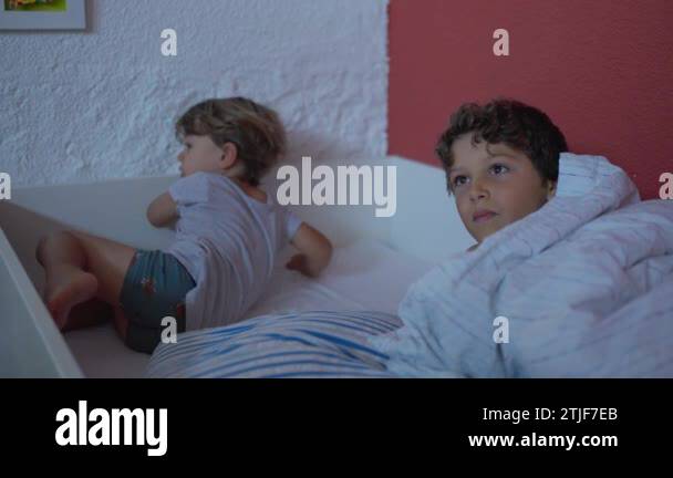 Two brothers in morning bed. candid authentic real life siblings in ...