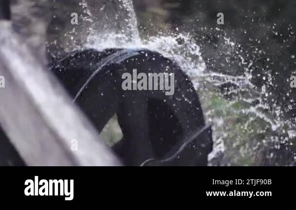 Slow motion close up of an historic ancient wooden water wheel of a ...