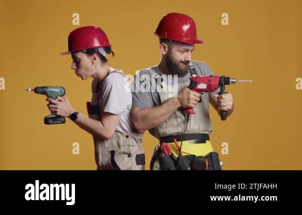 Construction workers using power drill gun to work on industrial ...