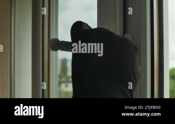 Close-up of a mans hand in a construction glove adjusting a window ...