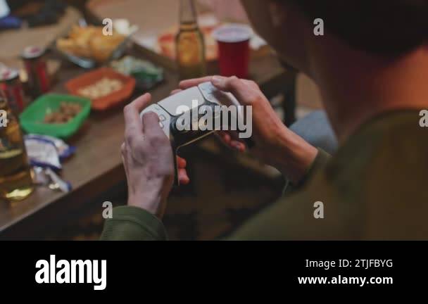 Close-up shoot. Guy is holding joystick and press buttons. Back view of ...