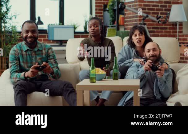 Cheerful people having fun with video games play, using tv console and ...