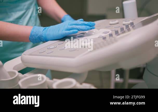 A gynecologist uses a transvaginal ultrasound device presses buttons ...