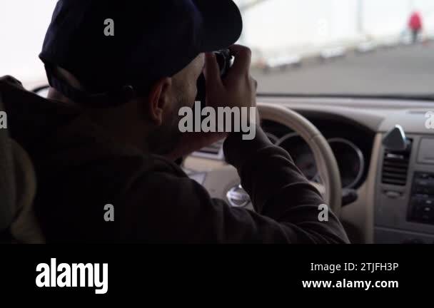 Private detective sitting inside car doing surveillance work ...
