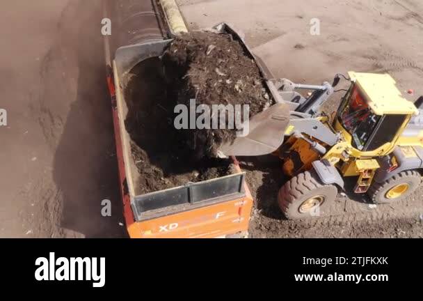 Industrial compost production site. Machines screening compost piles ...