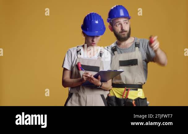 Construction workers calculating measurement on papers, taking notes ...