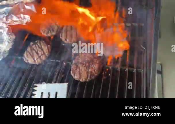 steak bbq burger patties fry over an open fire on the grate flip flame ...