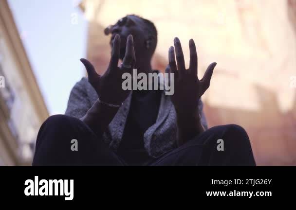 Man clapping his hands and making hand gestures while sitting in the ...