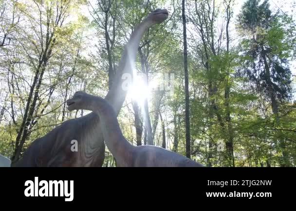 The biggest dinosaurs. A mother dinosaur with her cubs is standing in ...
