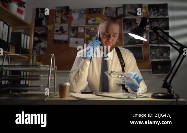 Forensic scientist working with evidence in gloves calling phone the ...