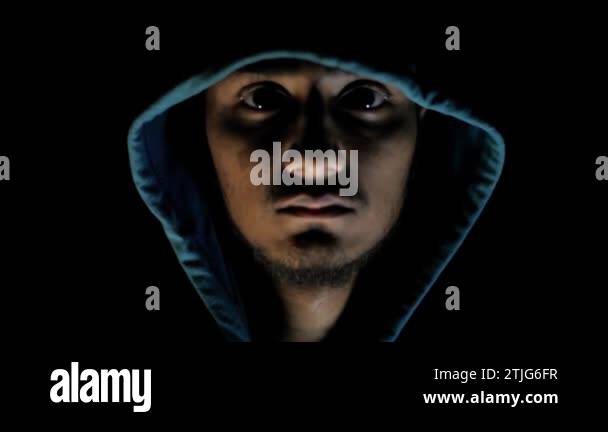 Close-up shot of a boy in a hoodie walking in the darkness looking ...