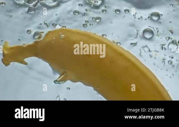 Closeup fresh banana water floating in light background. Yellow ...