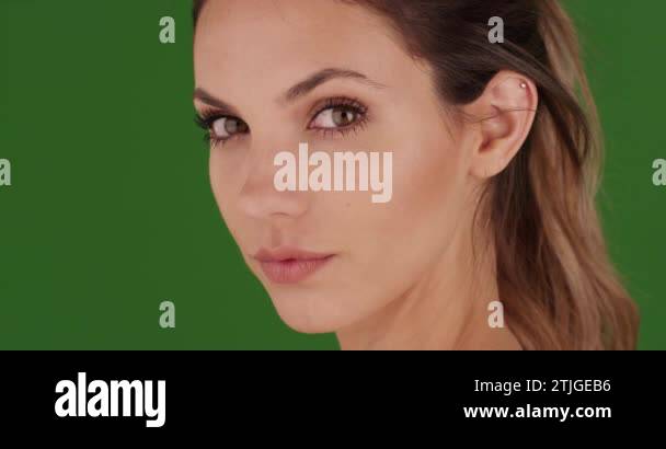 Close headshot of female model looking at camera on greenscreen ...