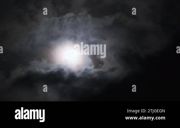 Full moon in the night sky moves through dark clouds, Timelapse. The ...