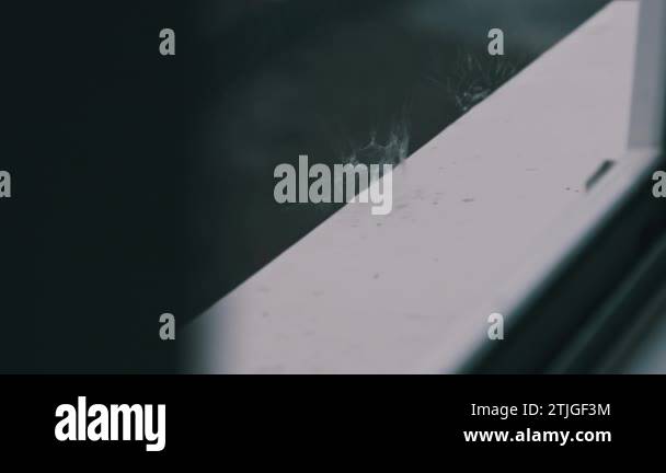 Rain drops beat against the window ledge in slow motion. Raindrops hit ...