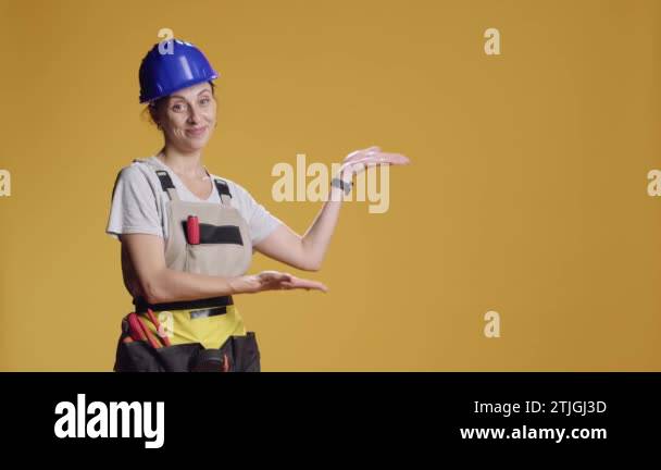 Portrait of construction worker advertising sideways space, pointing ...