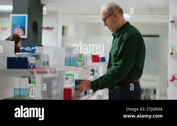 Senior client looking at medicaments boxes in pharmacy, buying ...