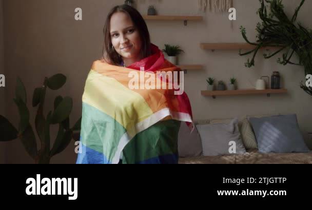 Lgbt women rest at home with pride rainbow flag. Embrace and holding ...