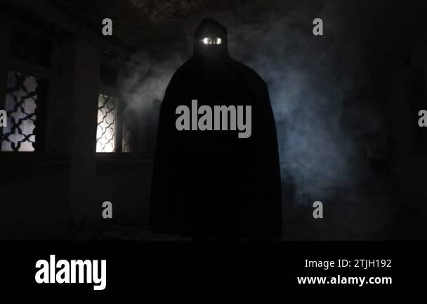 death in the hood standing in the dark hall. Horror silhouette inside ...