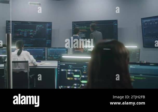 Female software engineer sits at computer with displayed blockchain network and surveillance ...