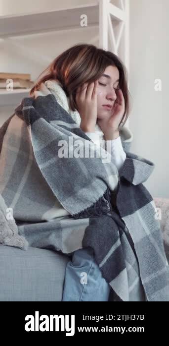 Vertical video. Headache suffer. Sick woman. Exhausted ill girl wrapped ...