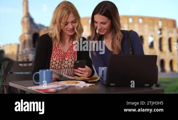 Couple of beautiful caucasian girls using tech devices with wifi to ...