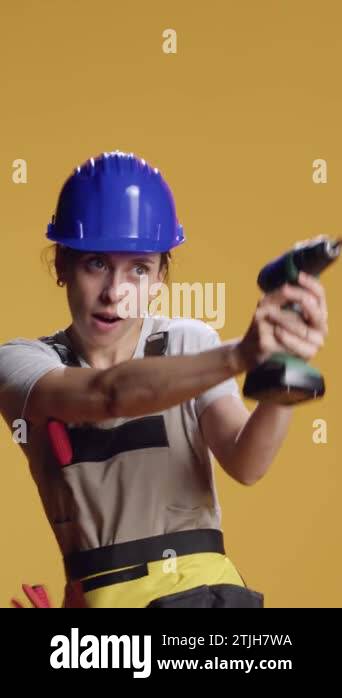 Vertical video: Construction worker having fun with power drill machine ...