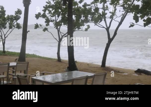Large storm waves crash onto beach as strong winds blow spray into the ...
