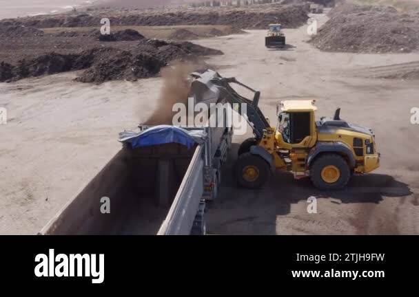 Industrial compost production site. Machines screening compost piles ...