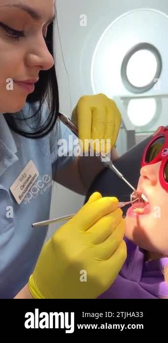 hands of an unrecognizable pediatric dentist call to a smiling cute ...