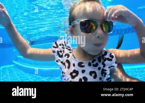 Little girls, sisters, triplets swim in a pool with a mask and snorkel ...