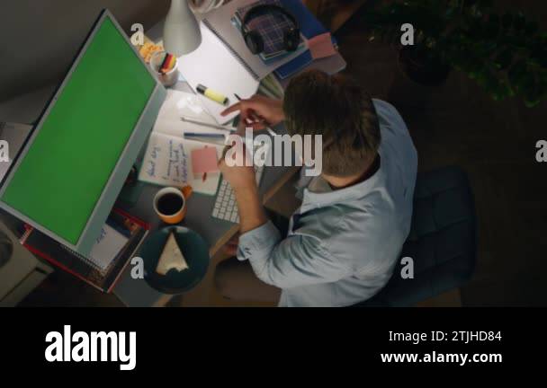 Anonymous freelancer working home top view. Ginger man writing notes at ...