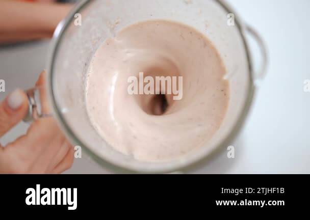 Closeup top view delicious milkshake mixing in slow motion and female ...