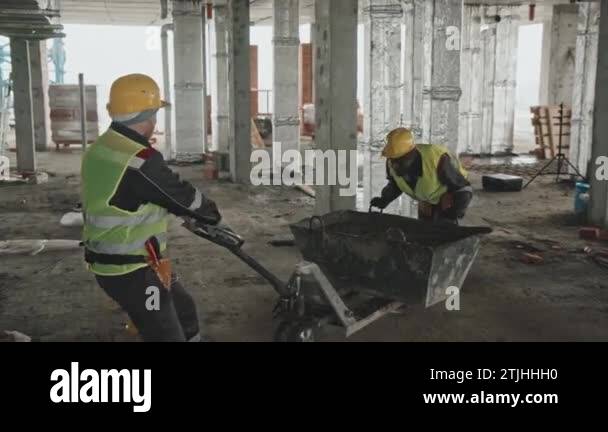 Strong Caucasian and African American construction workers pushing and ...