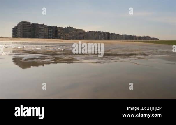 Beach of Wenduine and boardwalk with apartments during hot summer day ...