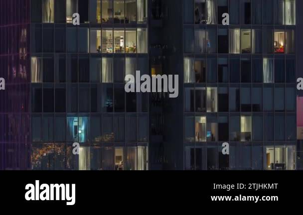 Frontal view of night facade of tower building with a lot of blinking ...