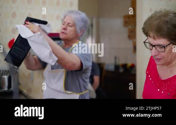 Two senior women doing domestic activity, candid and authentic elderly ...