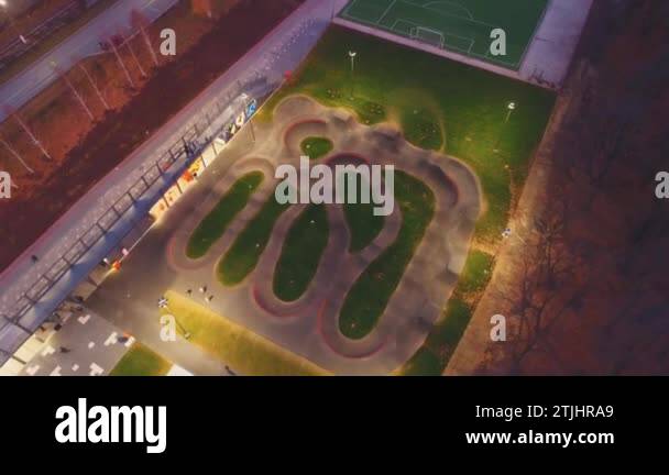Cycling tracks and skating ramps in large city park at night bird eye ...