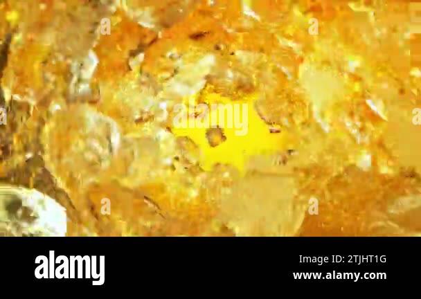 Super Slow Motion of Splashing Whiskey Wave With Ice. Creating Tunnel ...
