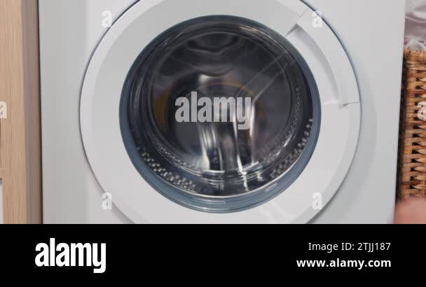 Close-up of hands trying to open the door of the washing machine, which ...