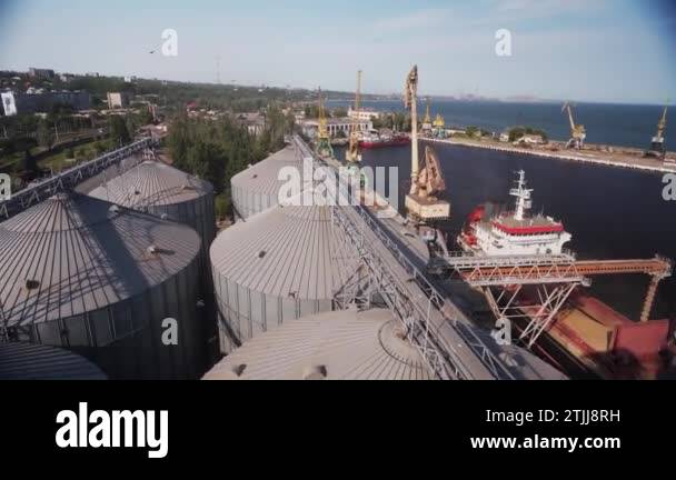 Modern grain elevator terminal in sea port. Metal tanks and conveyors ...