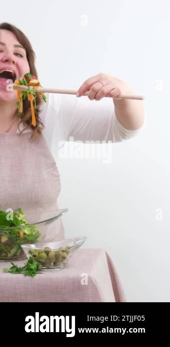 funny cheerful woman eating salad on white background she opens mouth ...