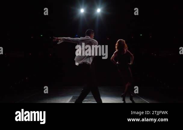 Ballroom dancers pair on concert hall stage,rear view.Slow motion ...