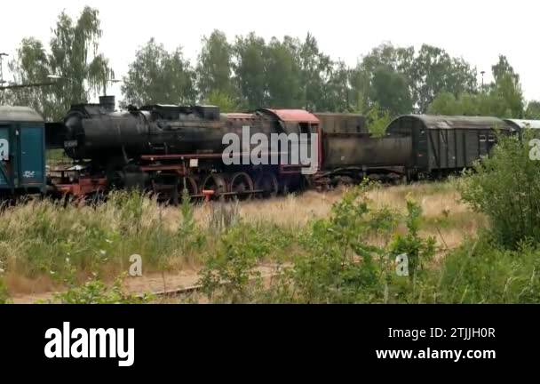 An old rusty black steam locomotive with a steam propulsion system and ...