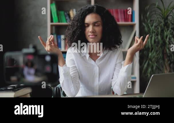 Relaxed young woman in casual wear sitting on workplace with modern ...