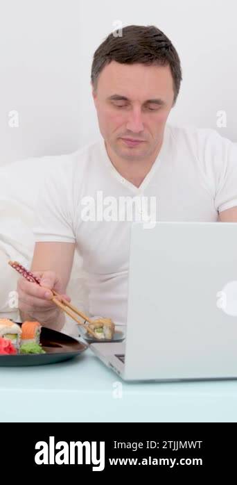 man white t-shirt eating sushi bed soy sauce putting wasabi top work ...