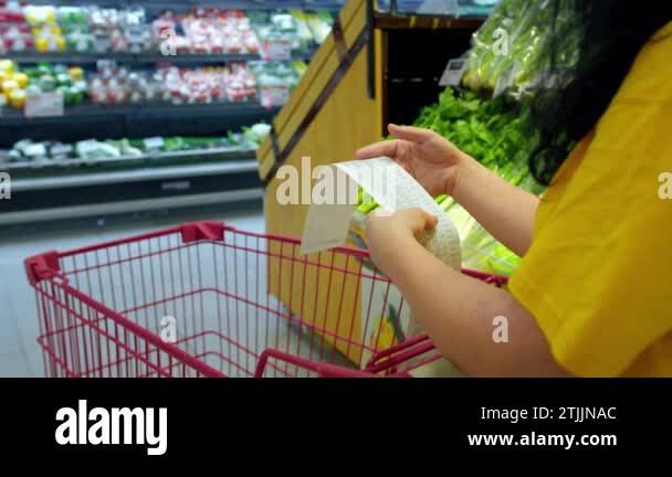 A woman checks a paper check after shopping for groceries at the mall ...