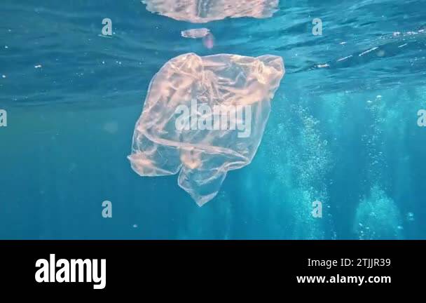 Piece of plastic bag floating in the sea. Danger of free-floating waste ...