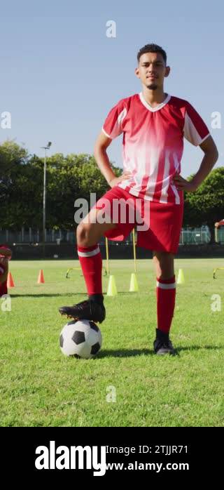 Vertical video of biracial football player on field with ball. Male ...